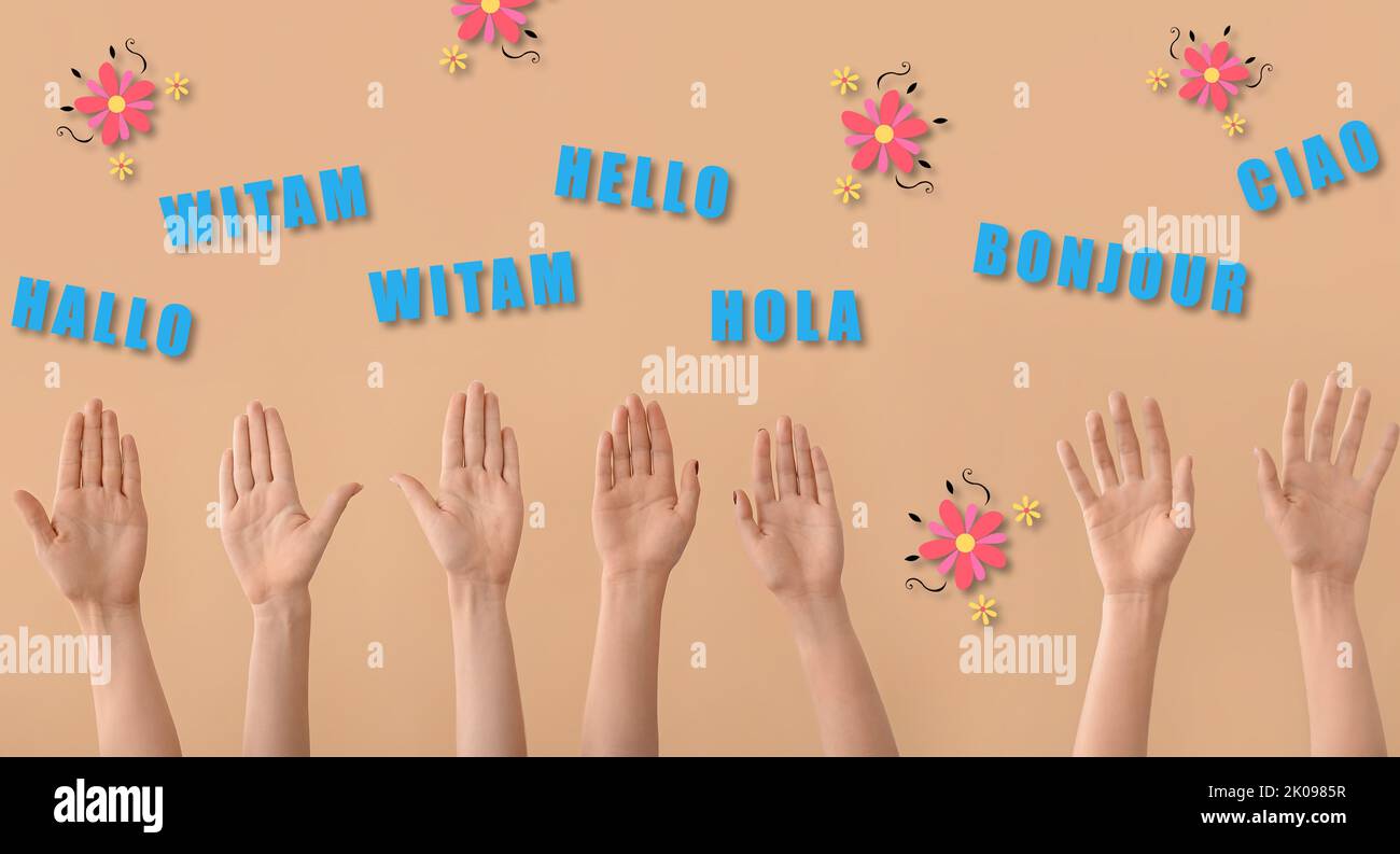 Many raised hands and words HELLO in different languages on beige ...