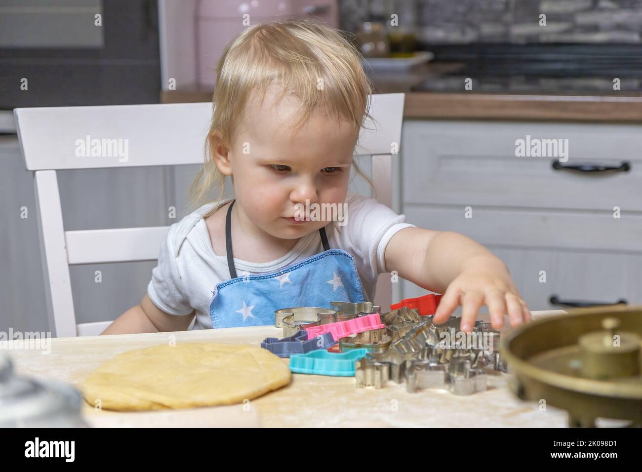 Adorable funny little child boy helps in the kitchen. Horizontally ...