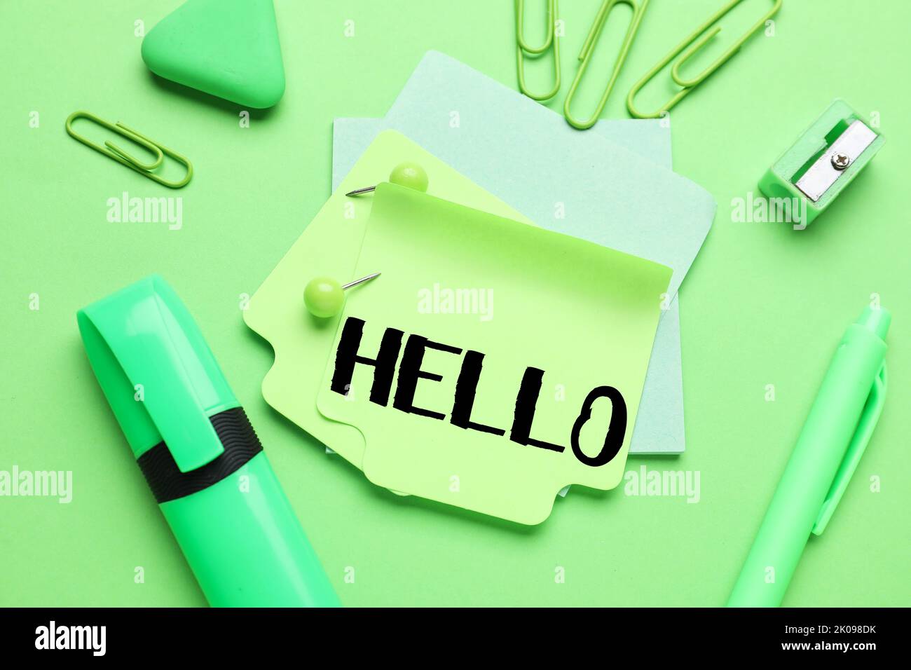 Sticky note with word HELLO and stationery on green background Stock ...