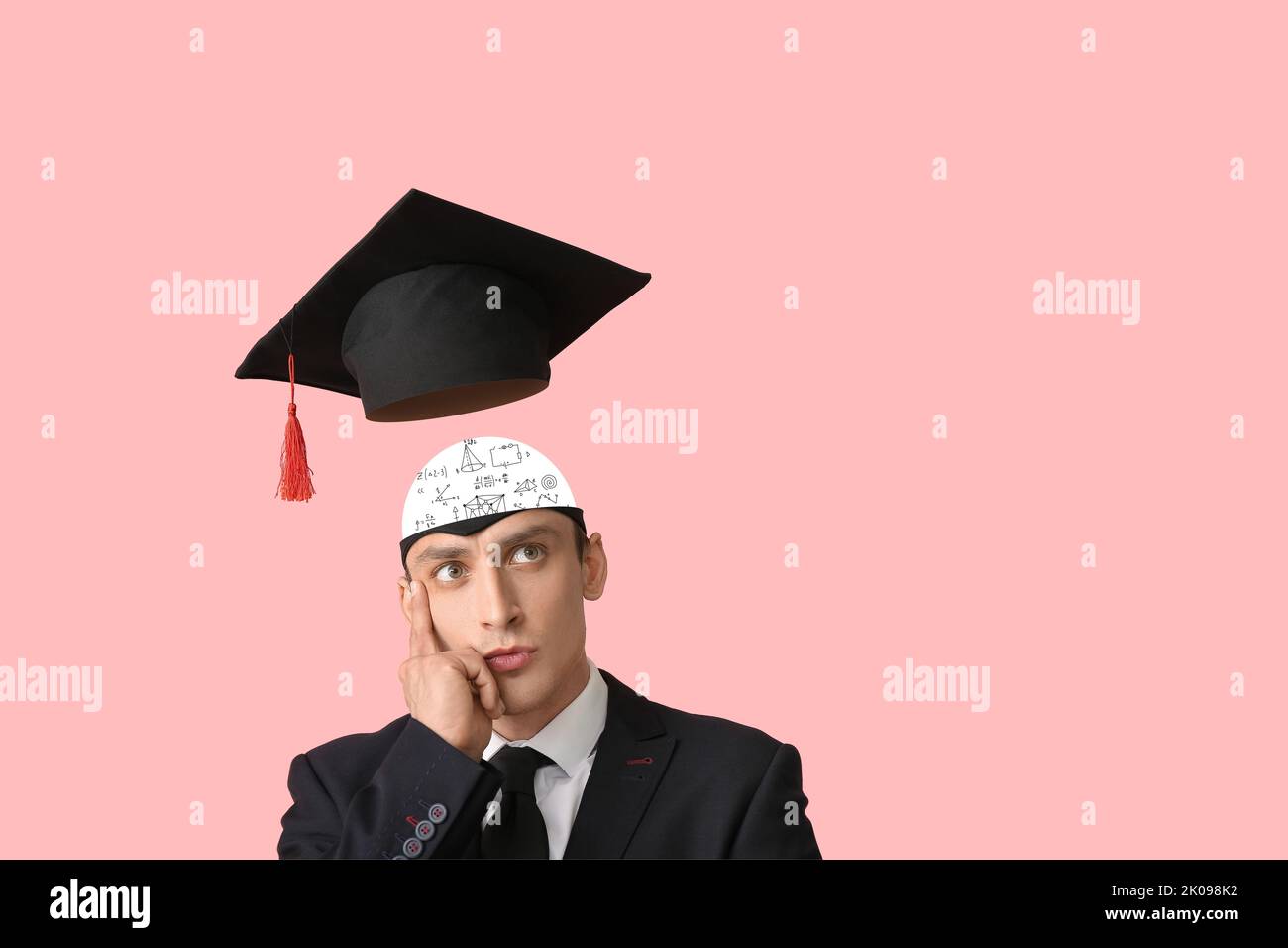 Smart man with graduation hat on pink background Stock Photo - Alamy