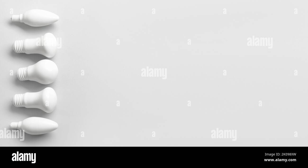 Different light bulbs on white background with space for text, top view ...