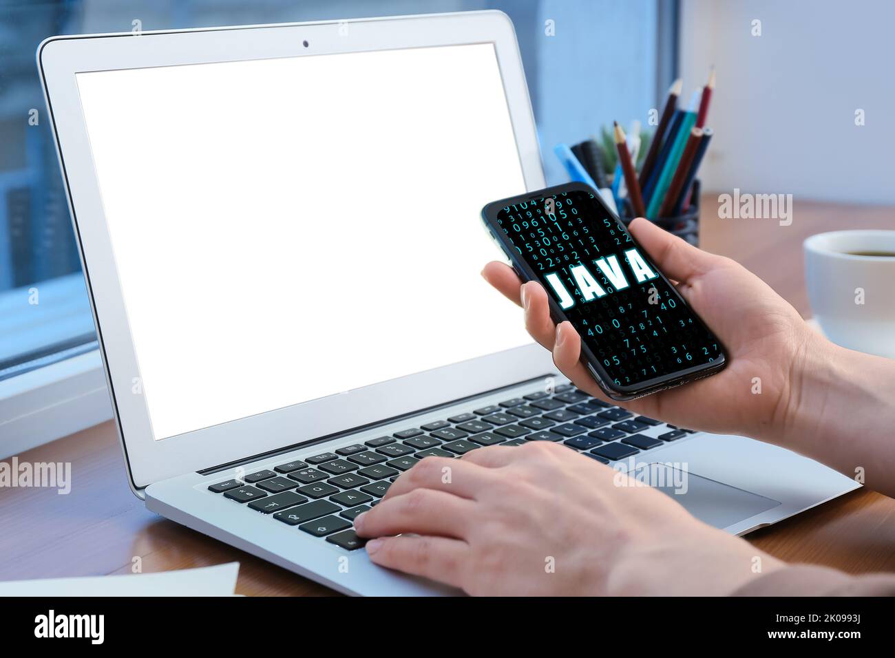 Female programmer with modern mobile phone and laptop in office Stock ...