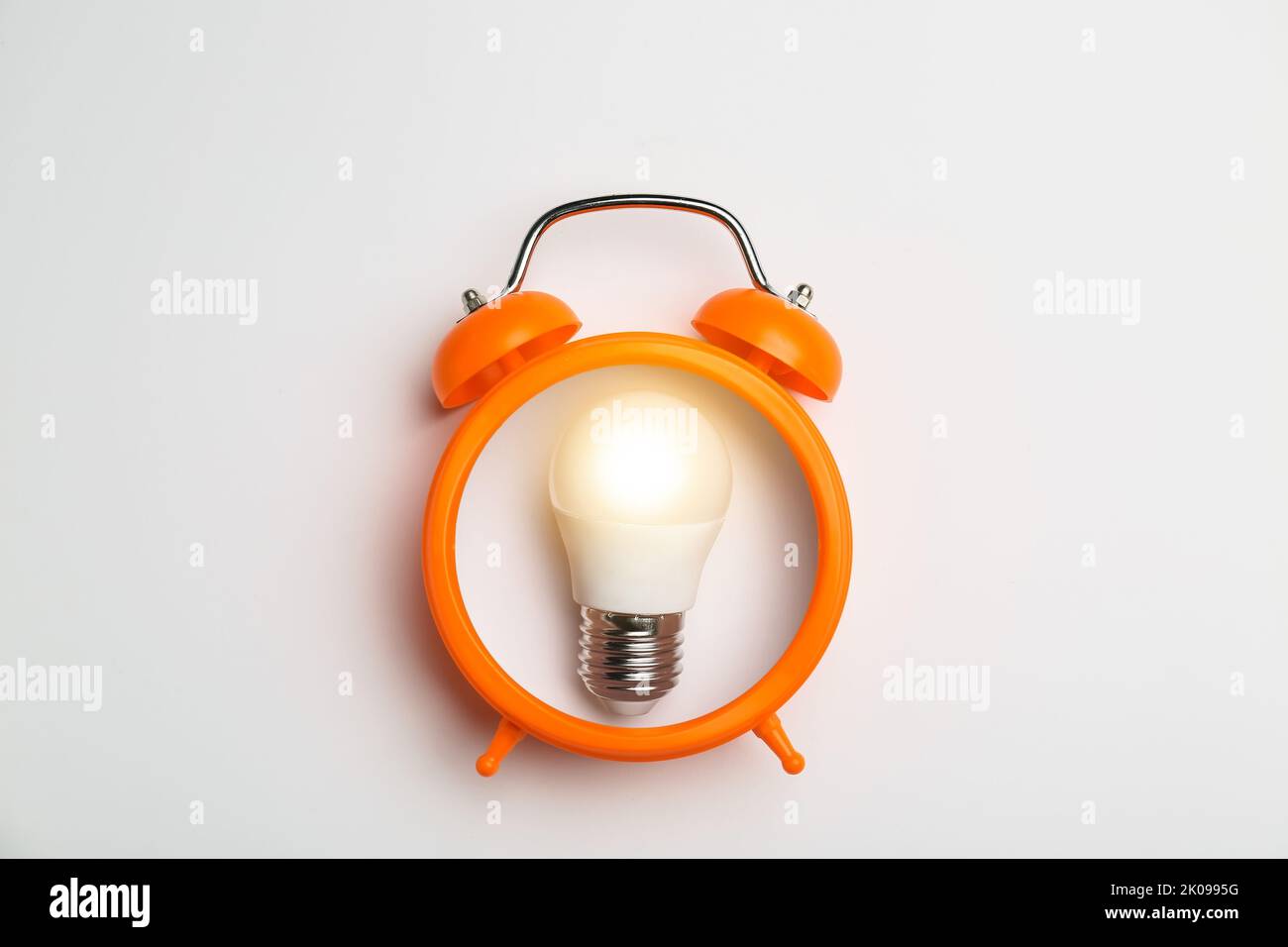 Light bulb with alarm clock on white background. Concept of idea Stock ...