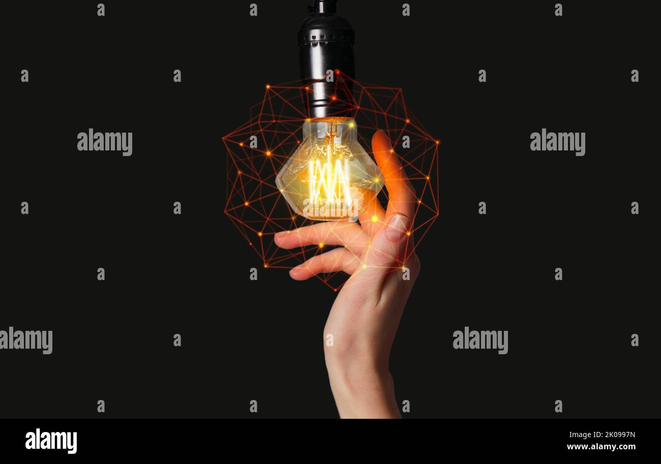 Female hand and glowing light bulb on black background Stock Photo - Alamy