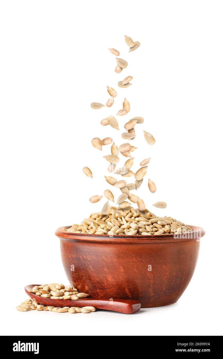 Peeled sunflower seeds falling into bowl on white background Stock ...