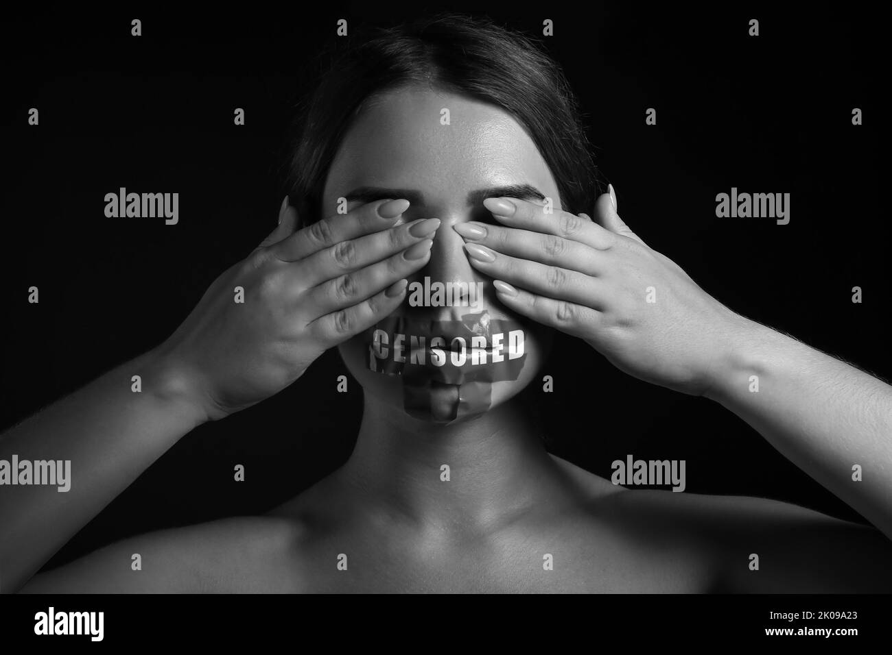 Black and white portrait of woman with taped mouth covering her eyes ...