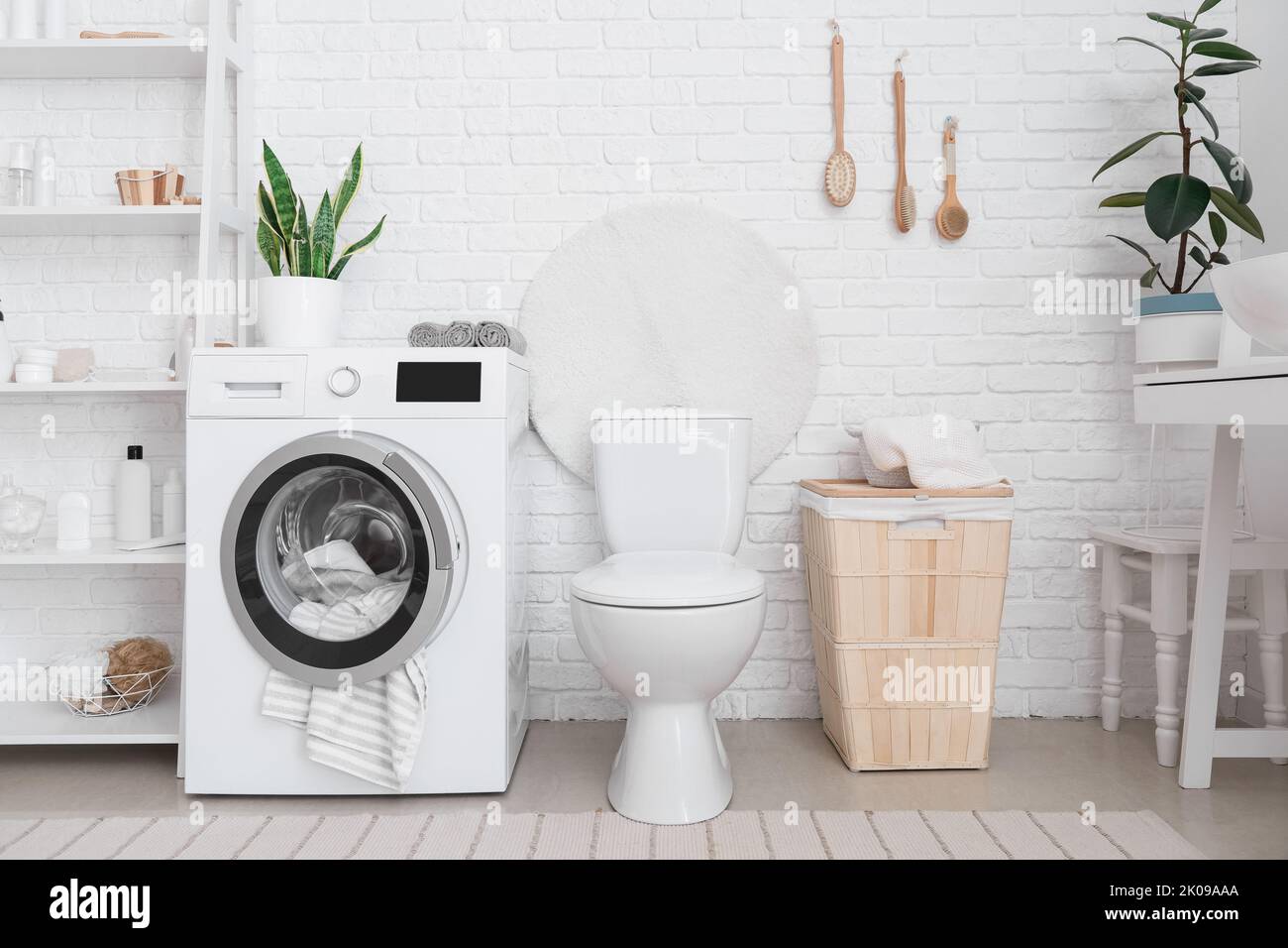 Interior of bathroom with modern washing machine, toilet bowl and shelf ...