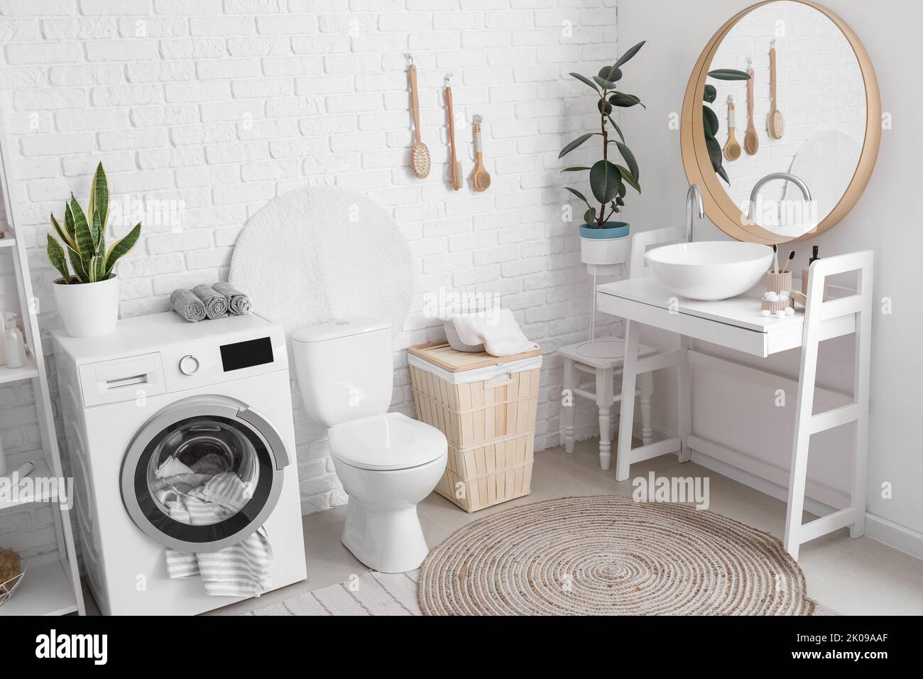 Interior of bathroom with modern washing machine, toilet bowl and sink ...