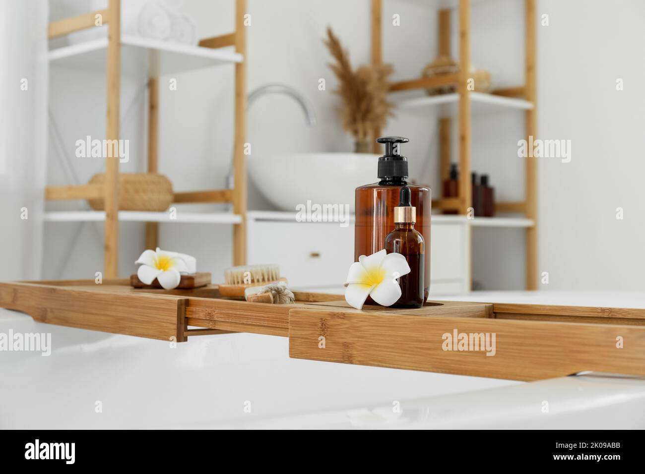 Bathtub tray with bath accessories and plumeria flowers, closeup Stock ...