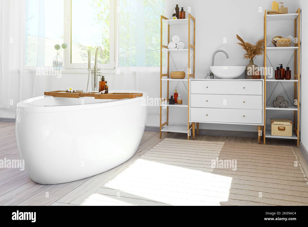 Stylish interior of bathroom with modern bathtub and shelf units with ...