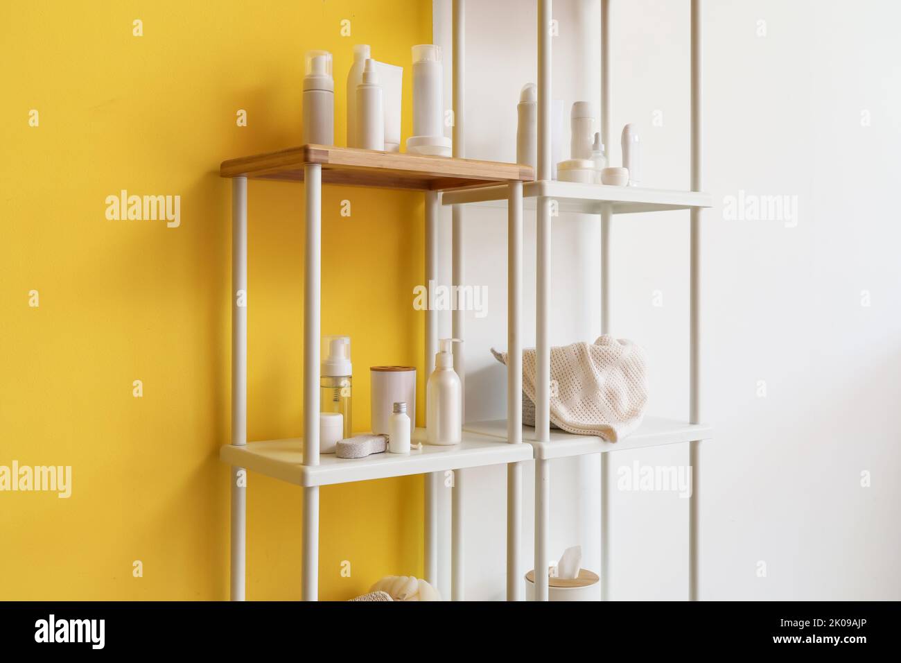 Shelf units with different bath accessories near color wall Stock Photo ...