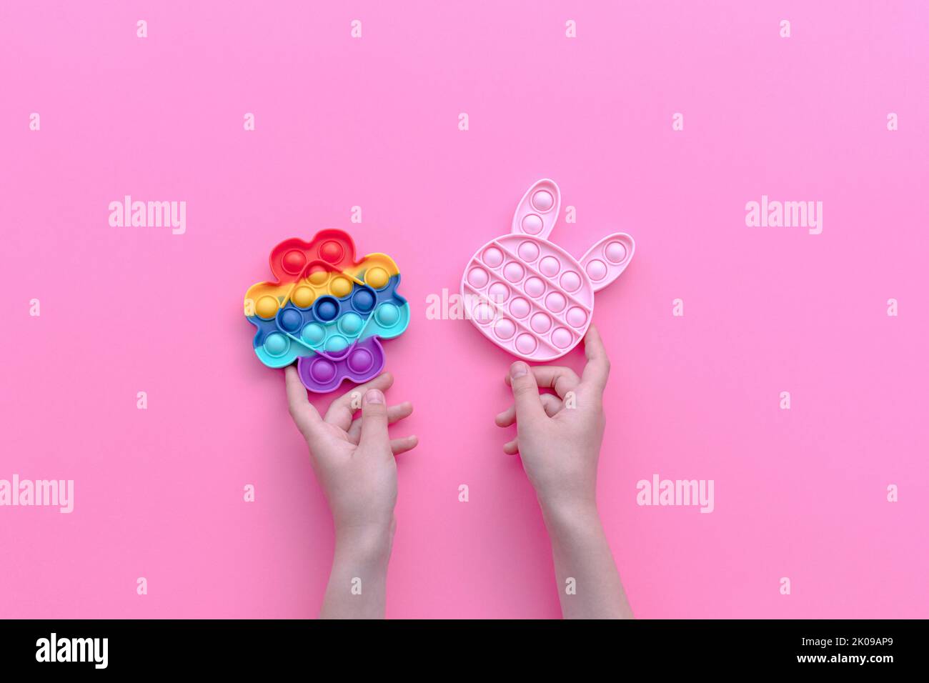 Child hands pointing to colorful anti-stress sensory fidget toys pop it ...