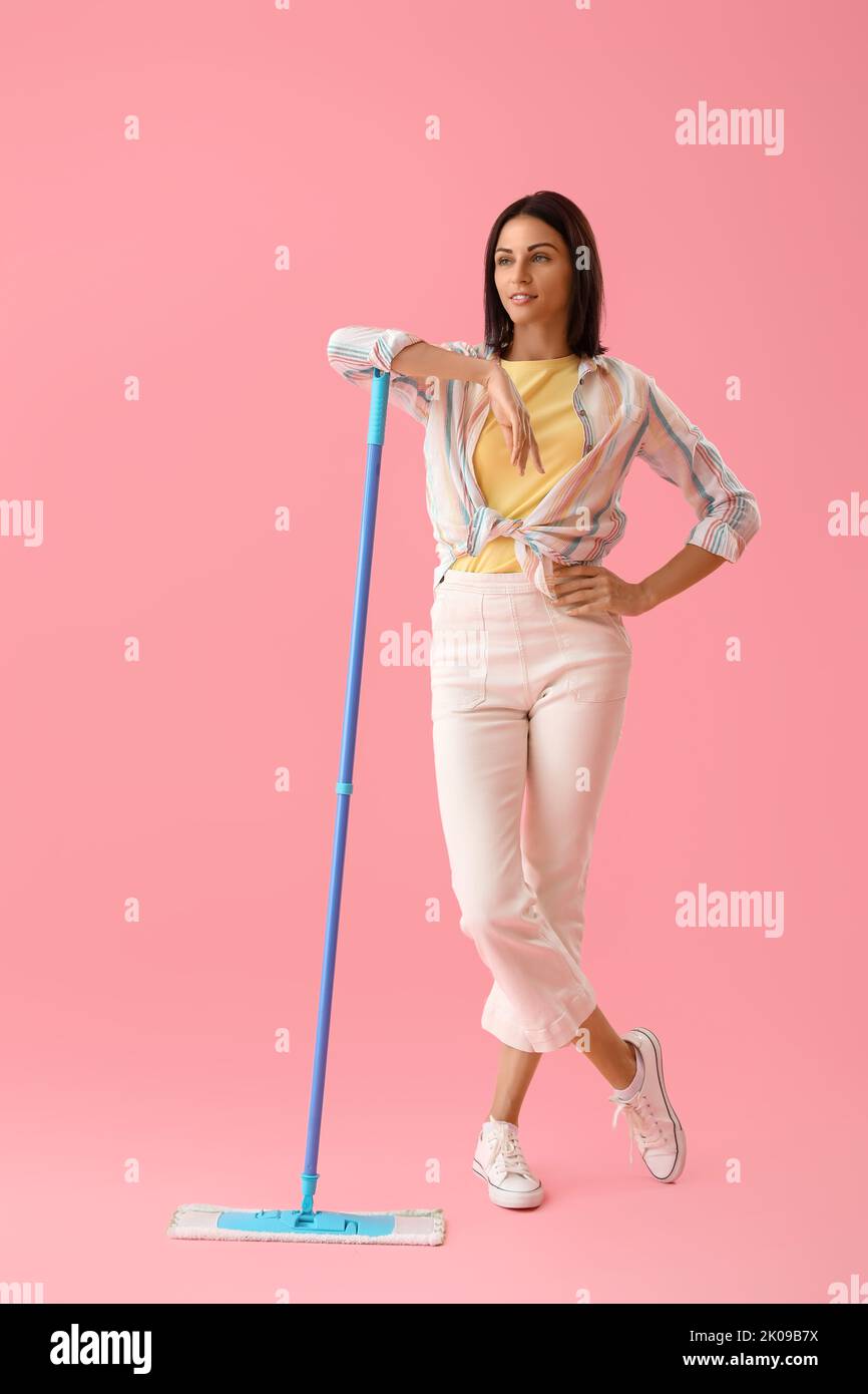 Beautiful woman with mop on pink background Stock Photo - Alamy