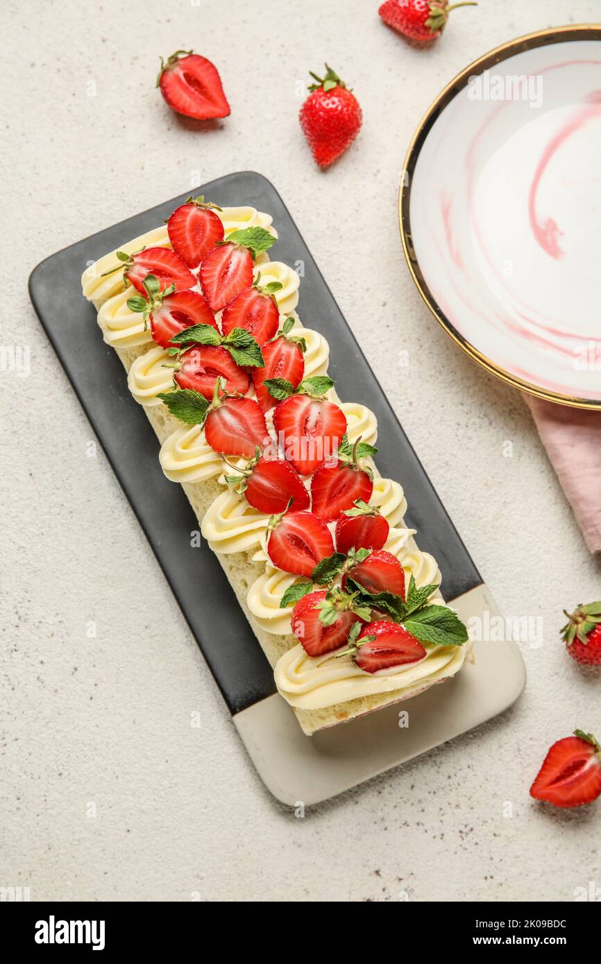 Plate of delicious strawberry roll cake on light background Stock Photo ...