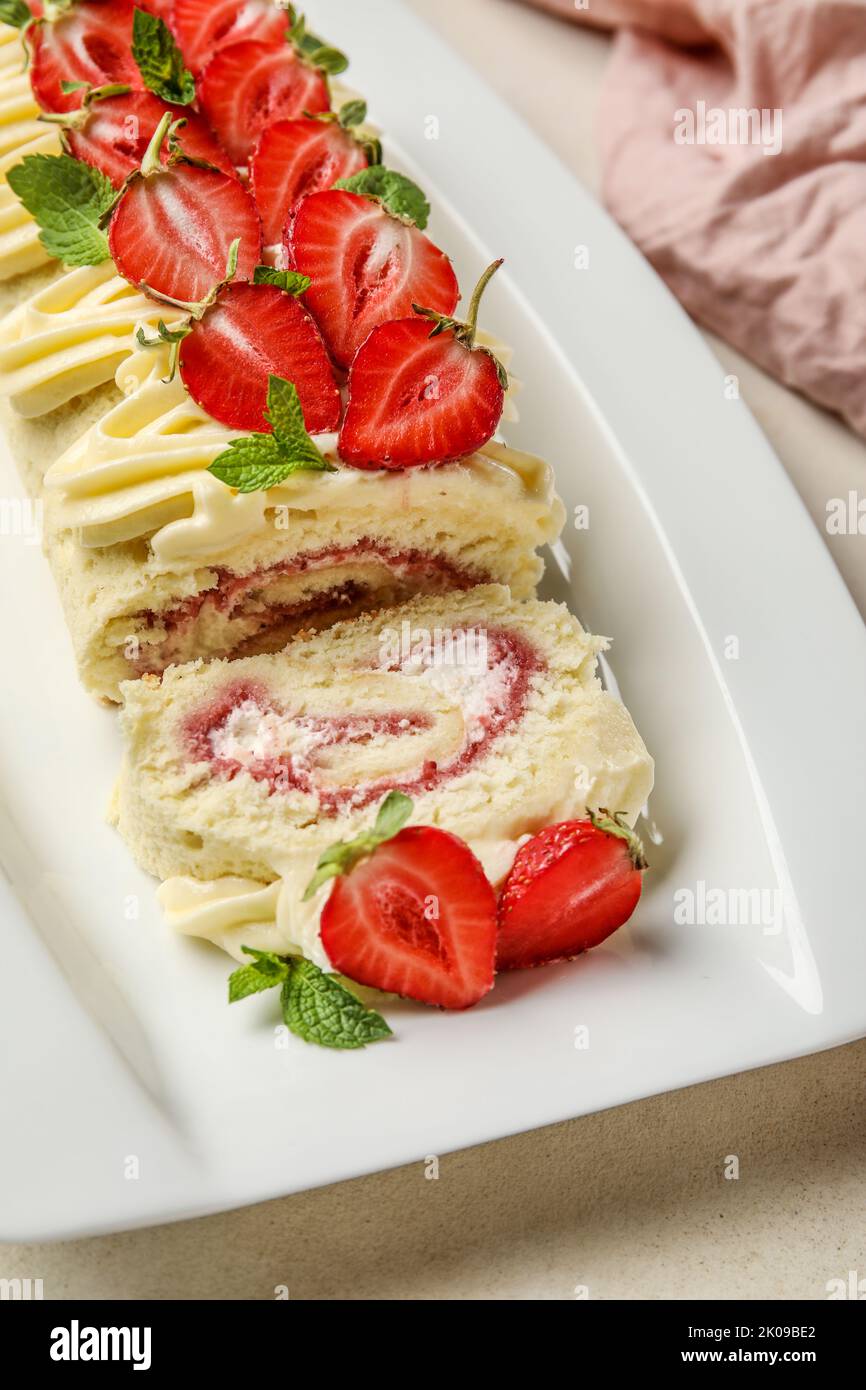 Plate with delicious strawberry roll cake on table, closeup Stock Photo ...