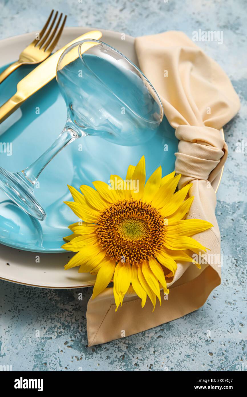 Stylish dinnerware and sunflower on blue table Stock Photo - Alamy