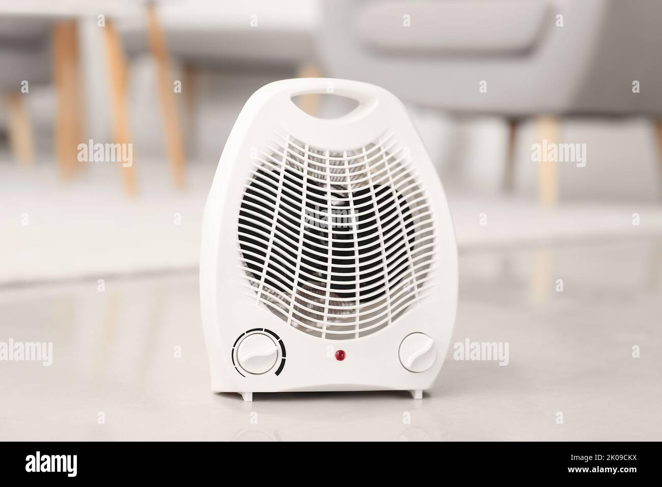 Electric fan heater on floor in living room Stock Photo - Alamy