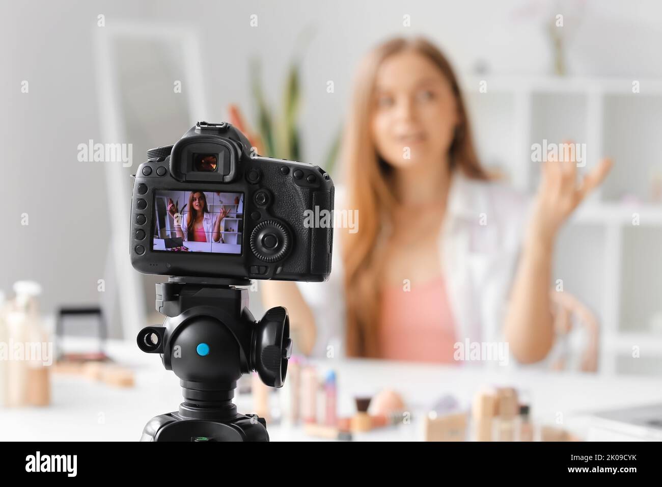 Female beauty blogger with lipstick on screen of camera in dressing ...