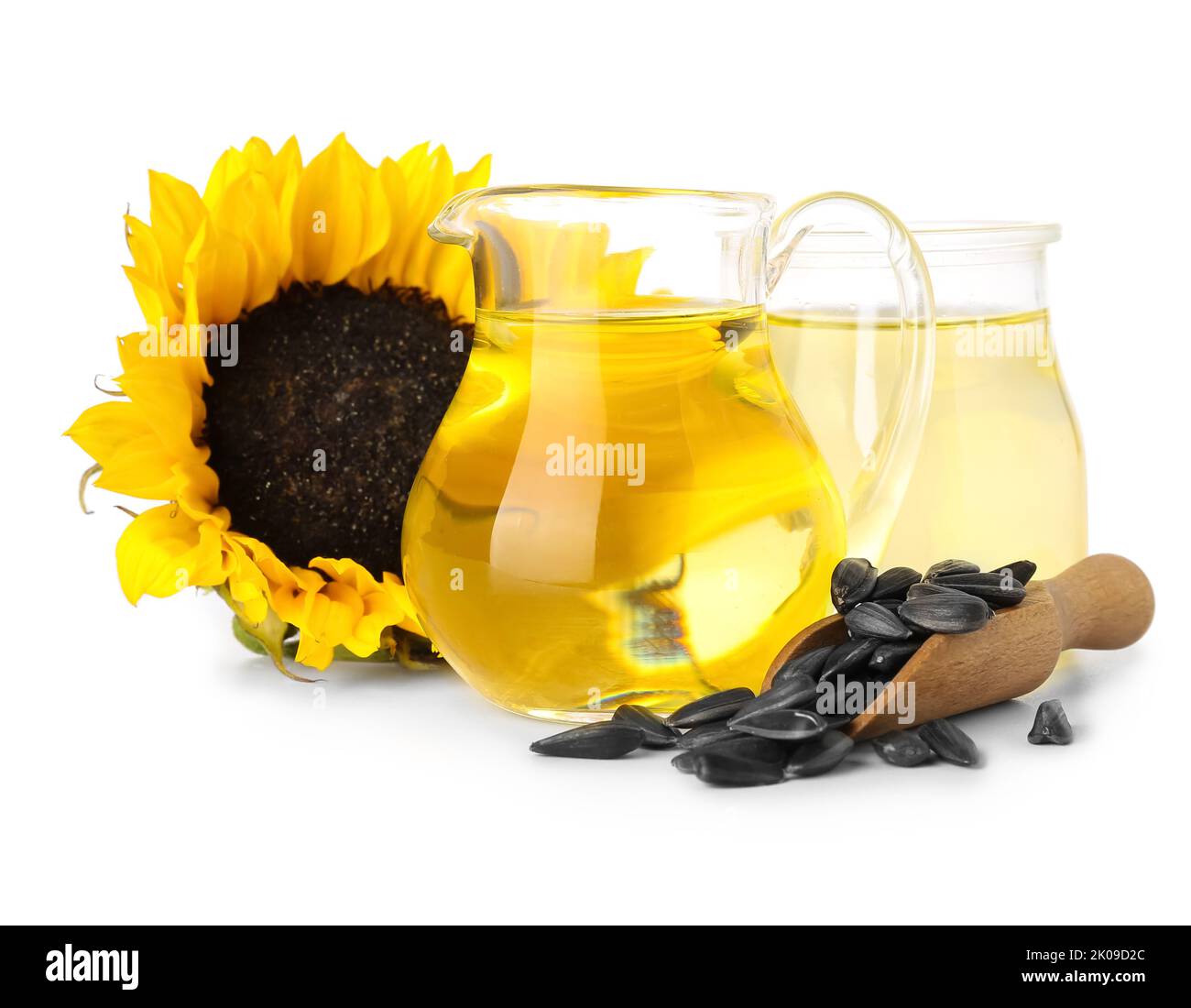 Sunflower with jugs of oil, scoop and seeds on white background Stock ...