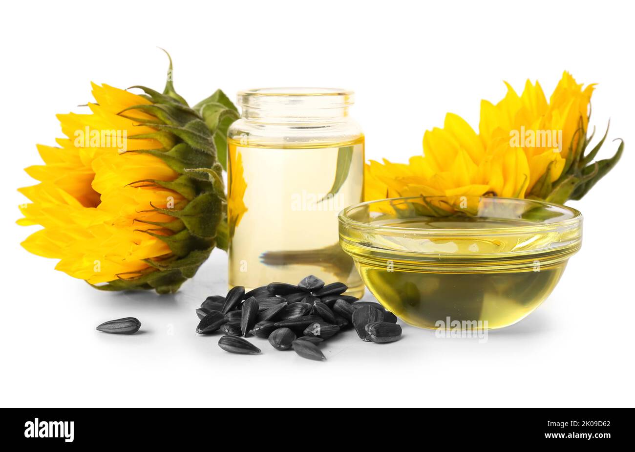 Sunflowers with glasses of oil and seeds on white background Stock ...