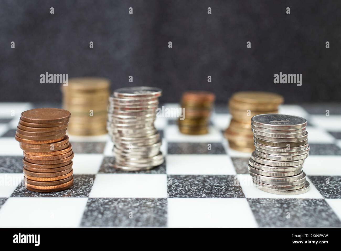 Multiple stacks of coins on a chess board, close up side view Stock ...