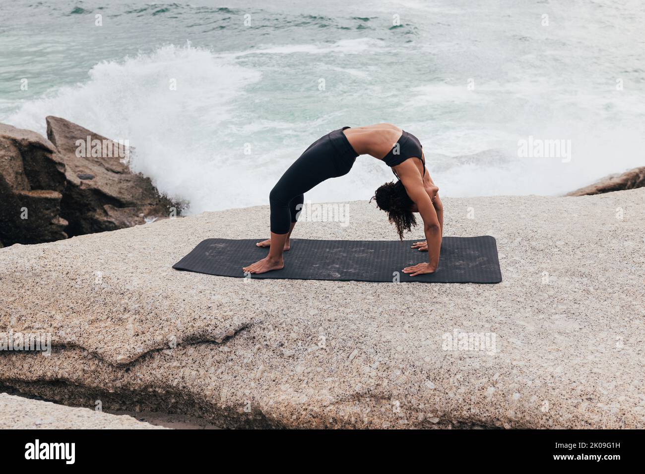 Side view of young slim female practicing Urdhva Dhanurasana. Woman in ...