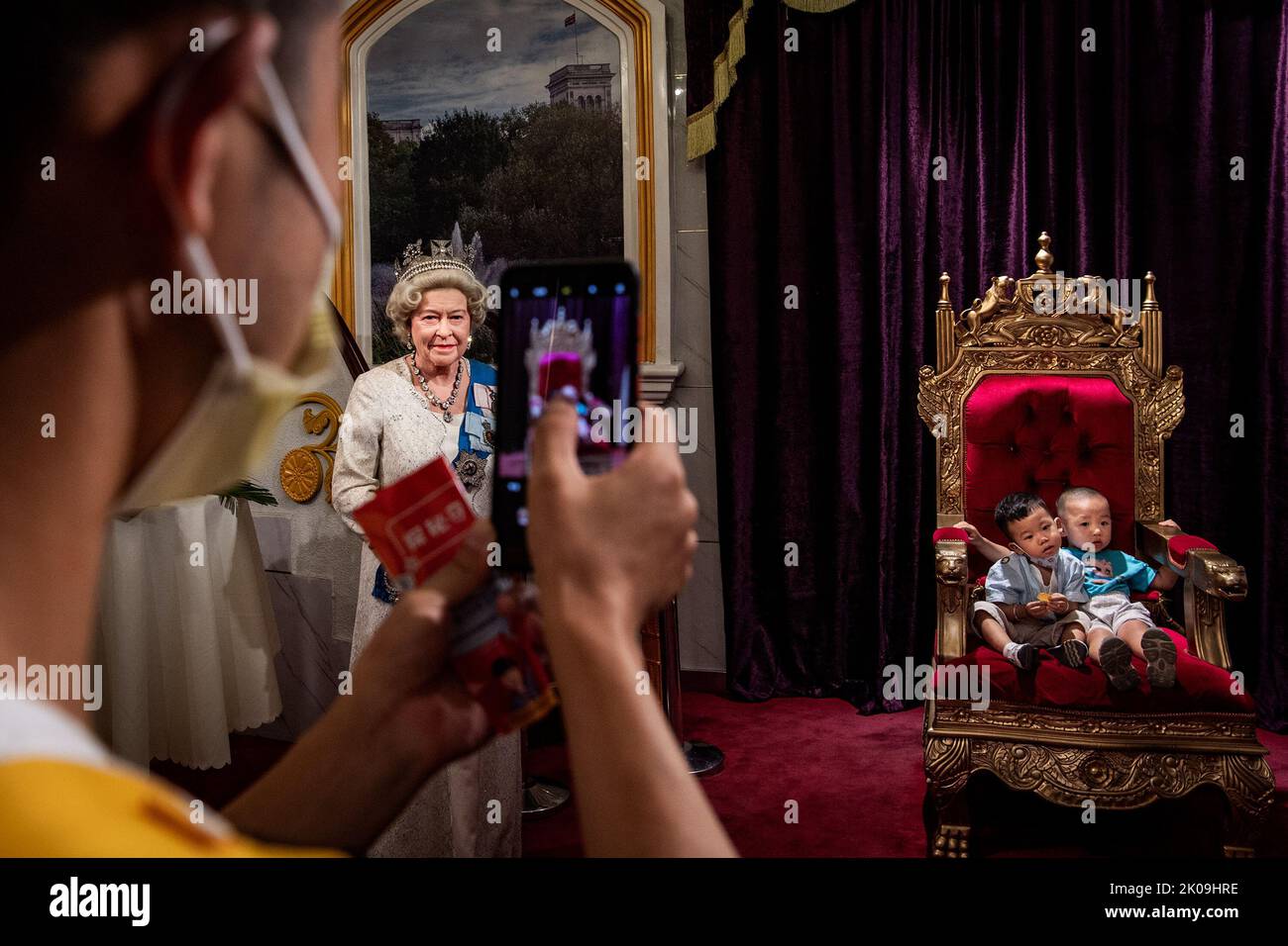 Two kids pose next to wax sculpture of Queen Elizabeth II at Wuhan ...