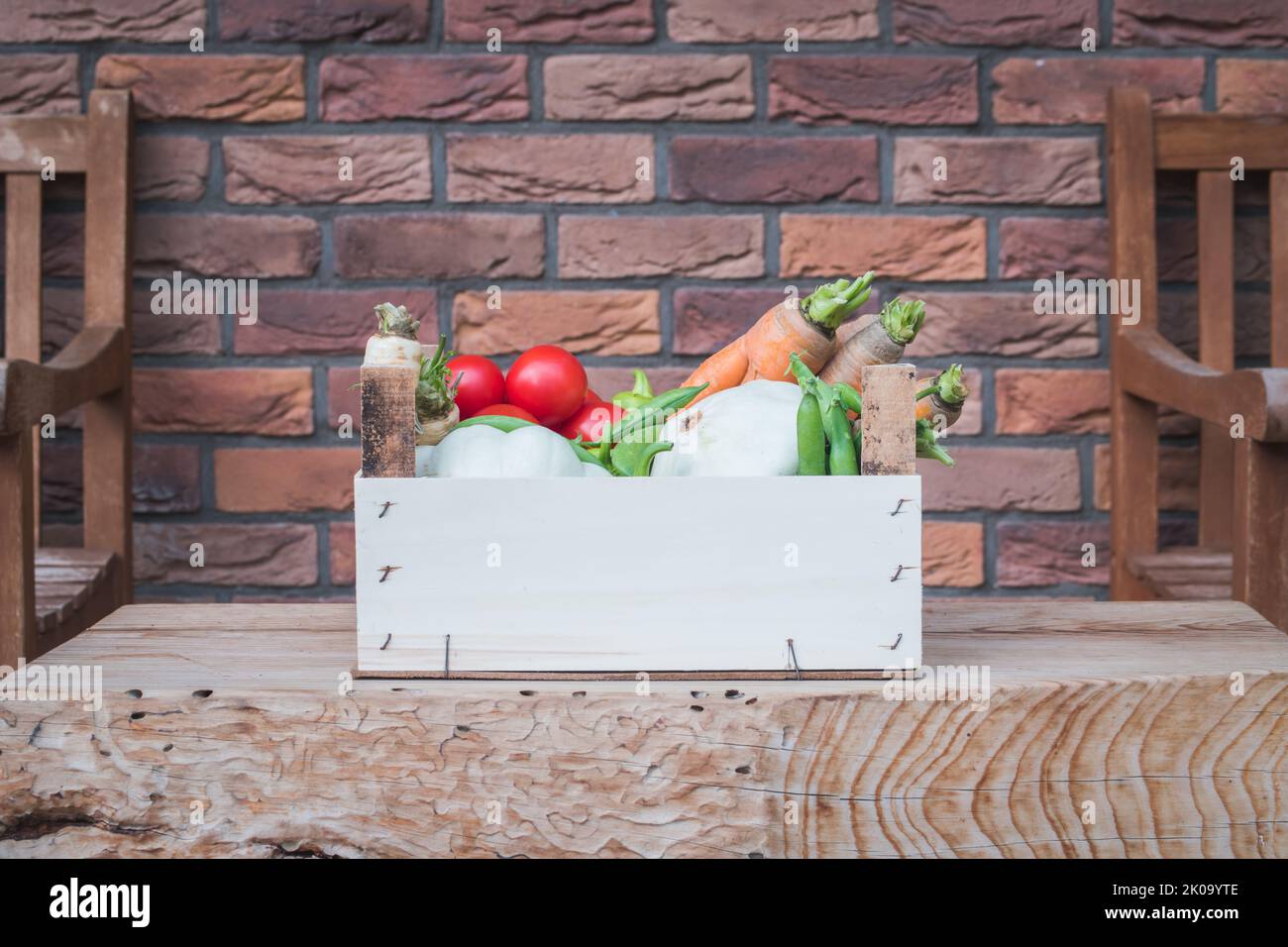 Wooden box full of fresh organic vegetables. Carrot, parsley, pea ...