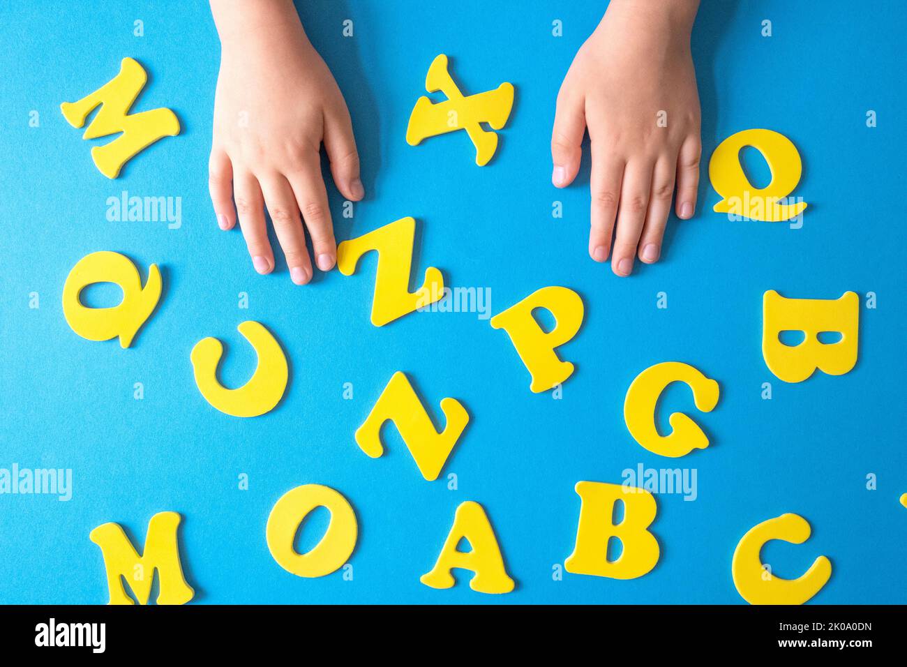 Yellow letters on a blue background. Child's hands lizenzfreie Bilder ...
