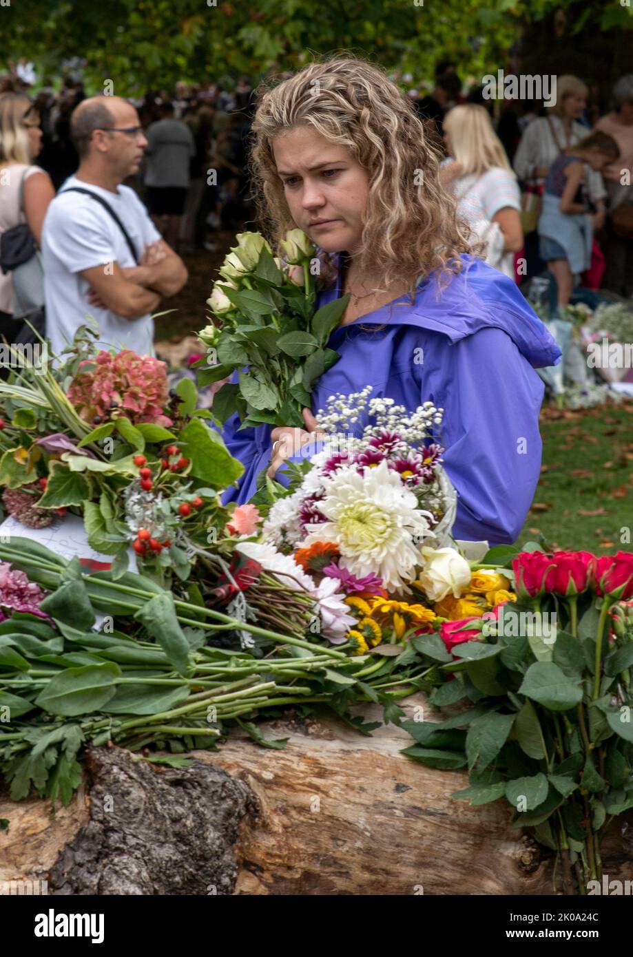 Members of the public gather to lay flowers in green park next to ...