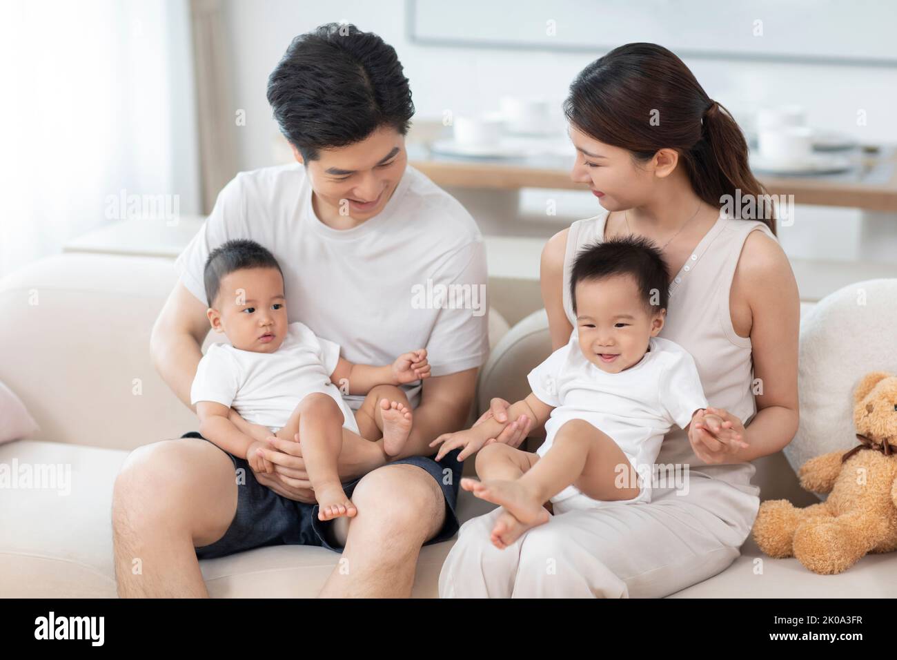 Young Chinese parents playing with twin babies at home Stock Photo - Alamy