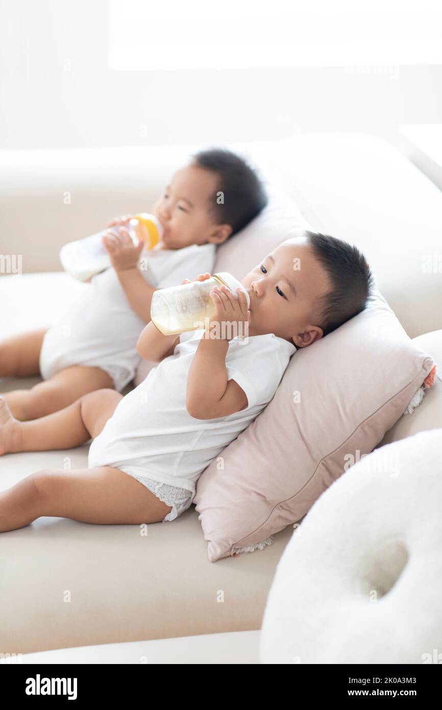 Cute Chinese twin babies drinking milk from baby bottles Stock Photo ...