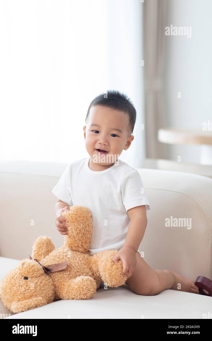 Cute Chinese baby playing with teddy bear Stock Photo - Alamy