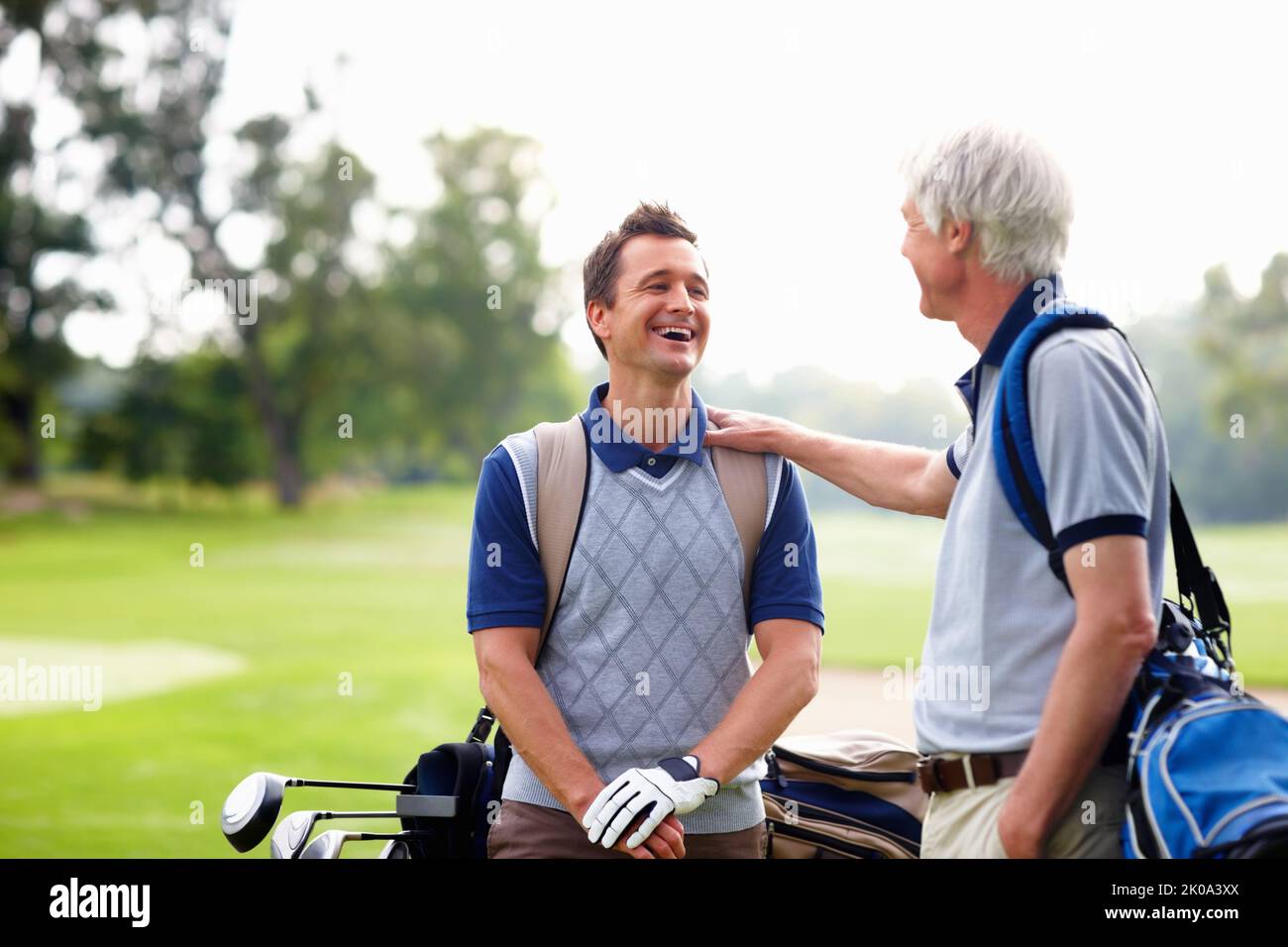 Male golfer in conversation with his father. Male golfer standing on ...