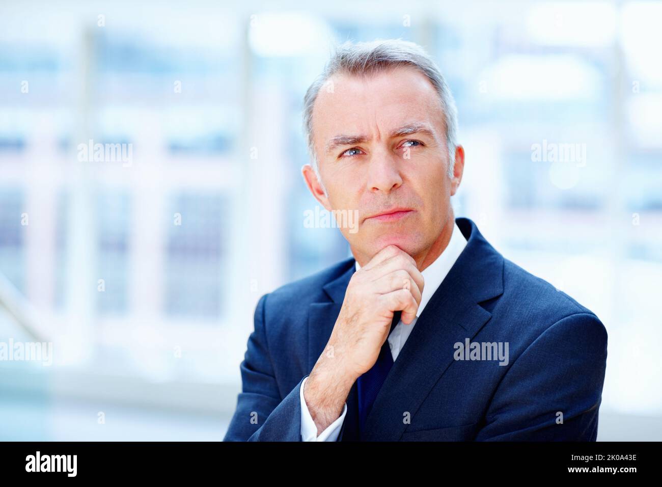 Executive deep in thought. Business man with hand on chin, looking off ...
