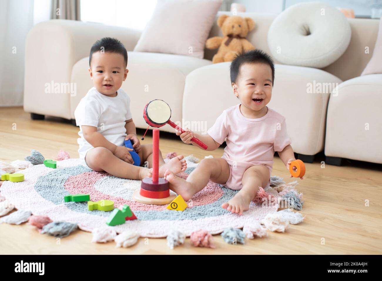 Cute Chinese twin babies playing with toys at home Stock Photo - Alamy