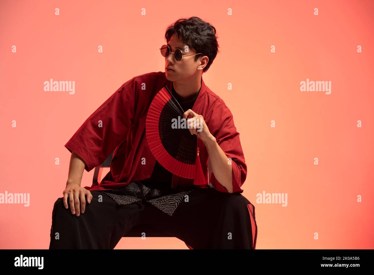 Confident young Chinese man holding a fan Stock Photo - Alamy