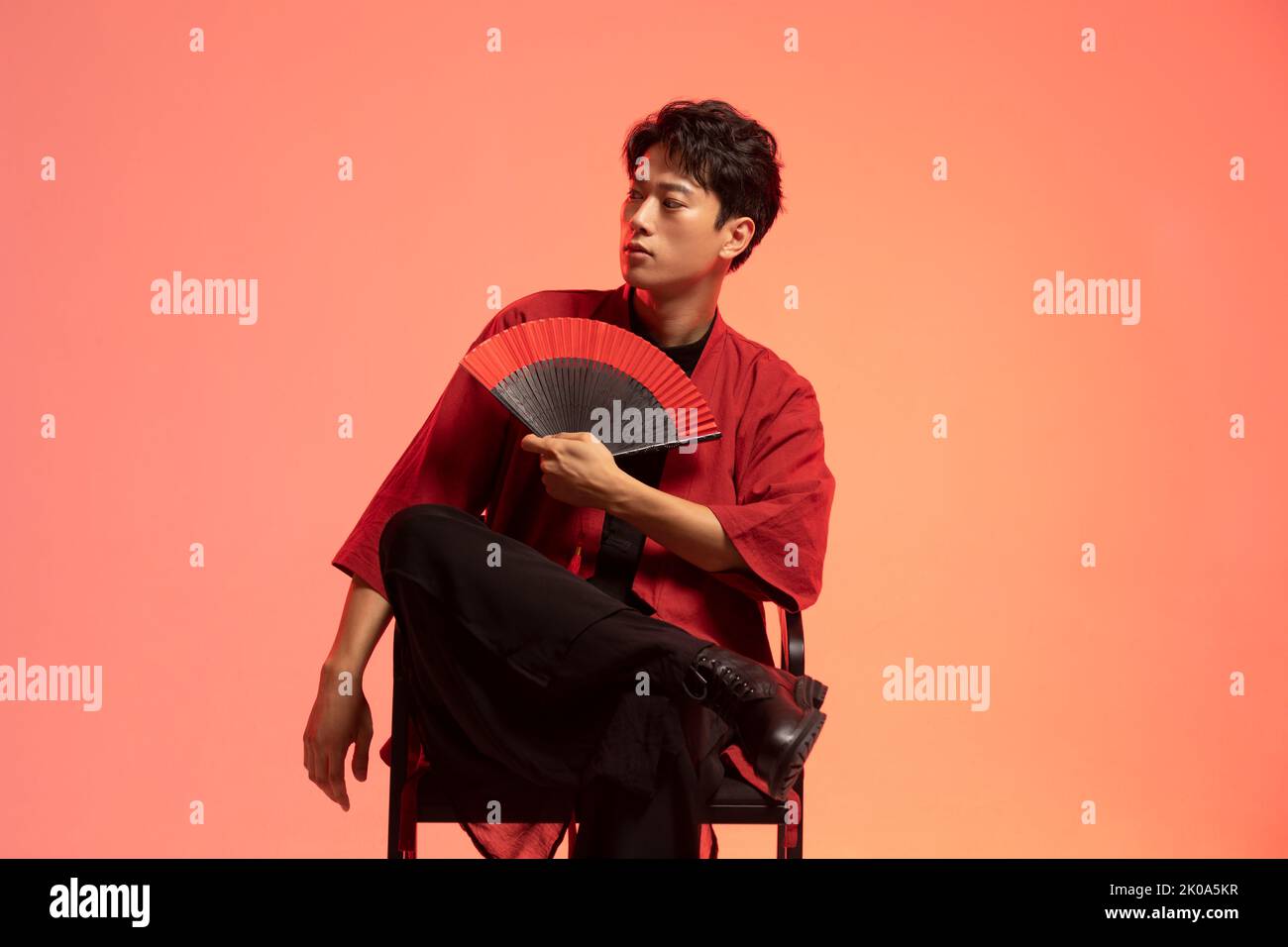 Confident young Chinese man holding a fan Stock Photo - Alamy