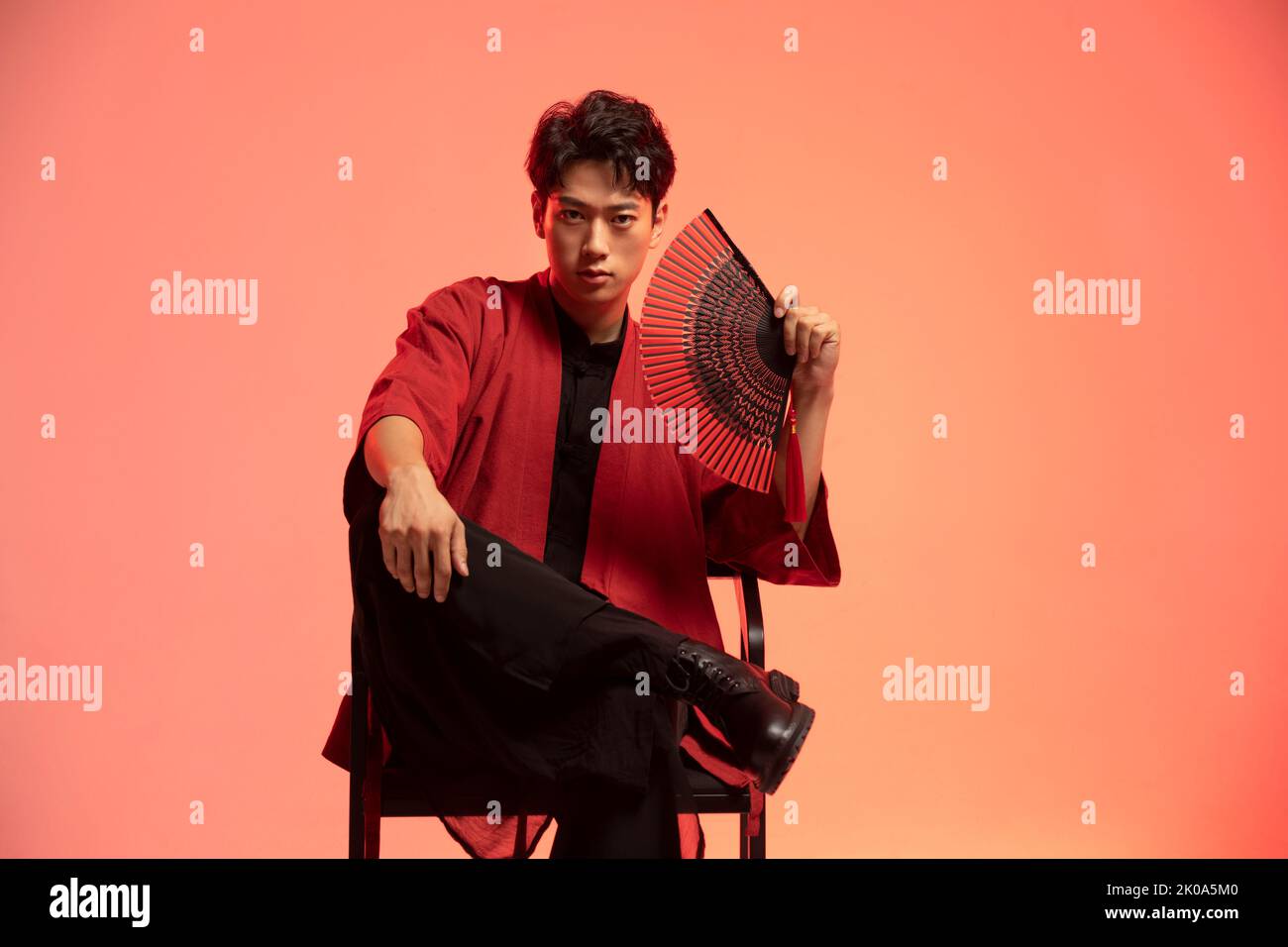 Confident young Chinese man holding a fan Stock Photo - Alamy