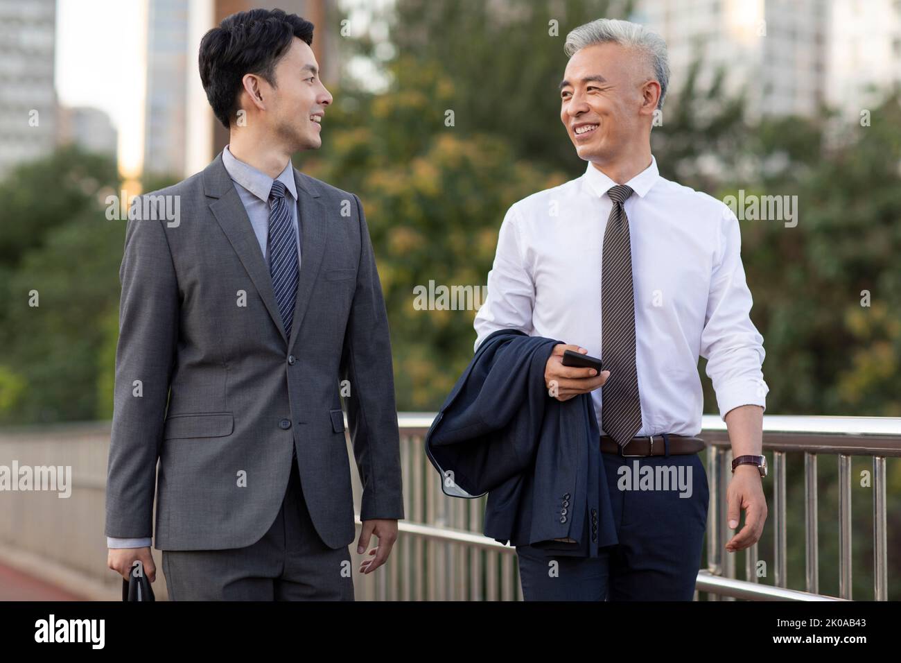 Confident Chinese businessmen talking outdoors Stock Photo - Alamy