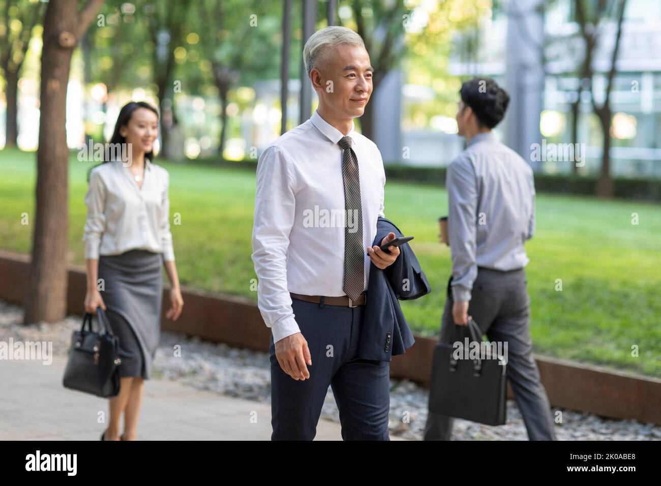 Confident Chinese business people walking outdoors Stock Photo - Alamy