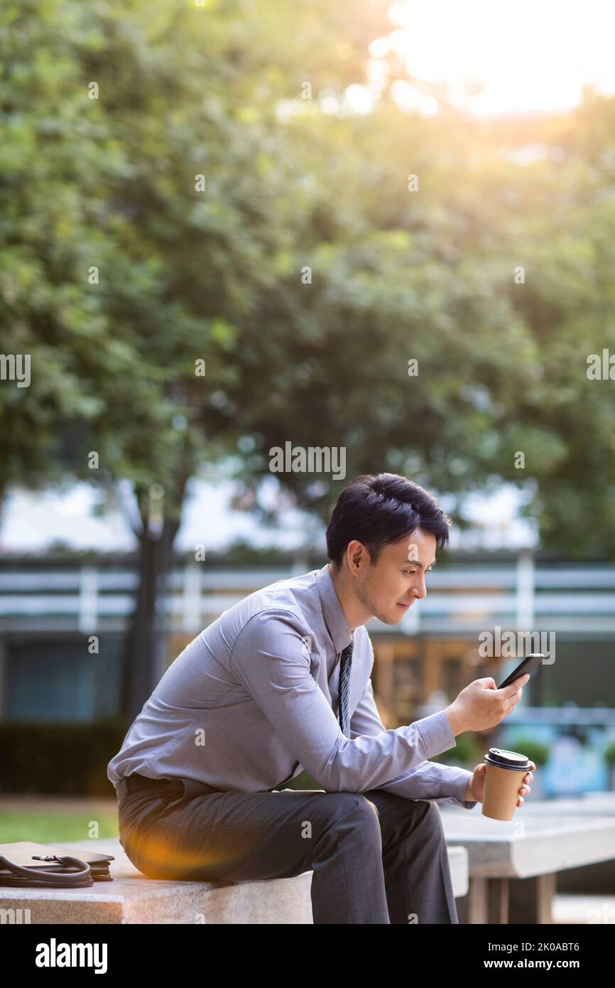 Young Chinese businessman using smart phone Stock Photo - Alamy