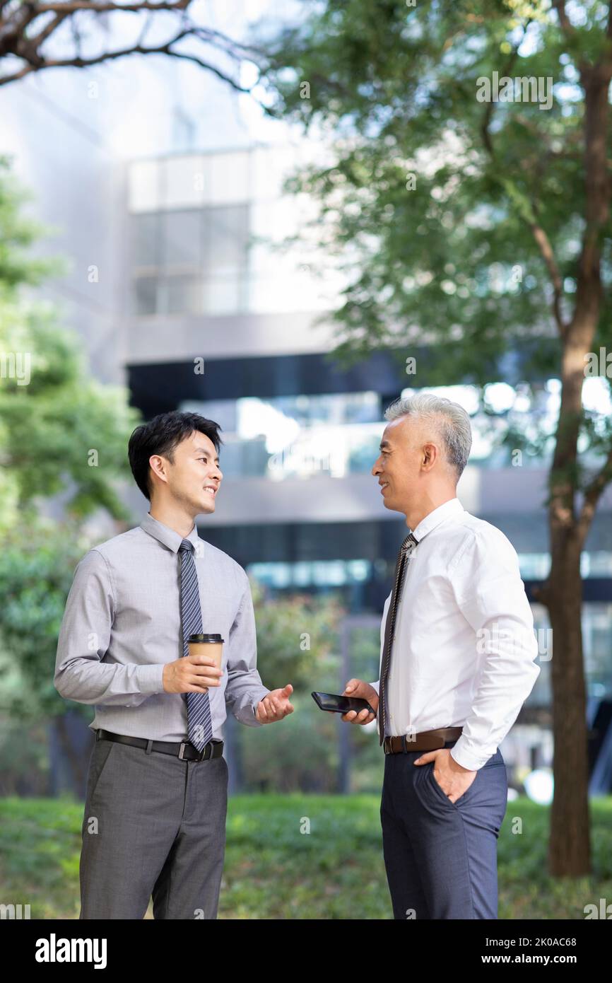 Confident Chinese business people talking outdoors Stock Photo - Alamy