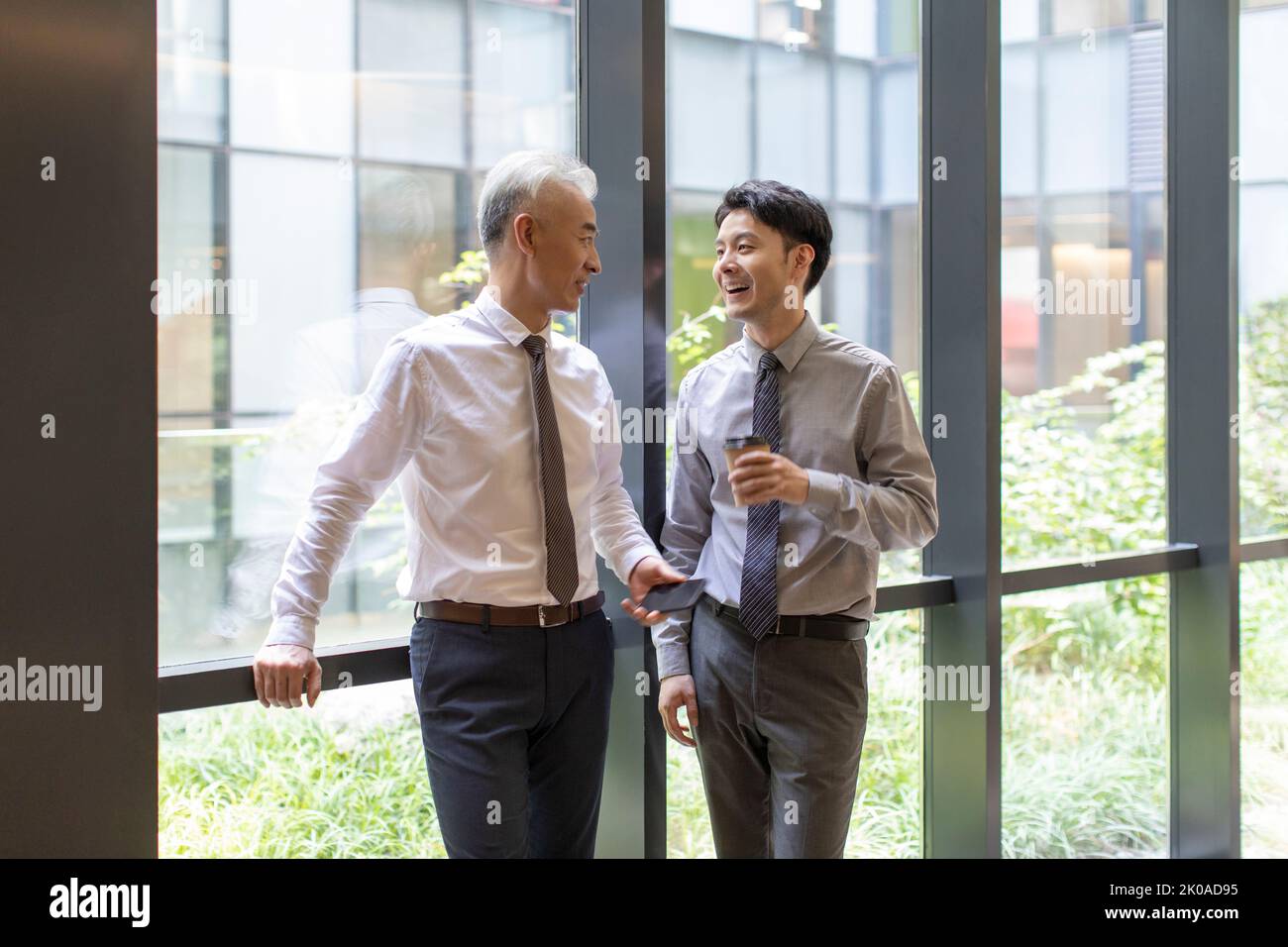 Confident Chinese business people talking Stock Photo - Alamy