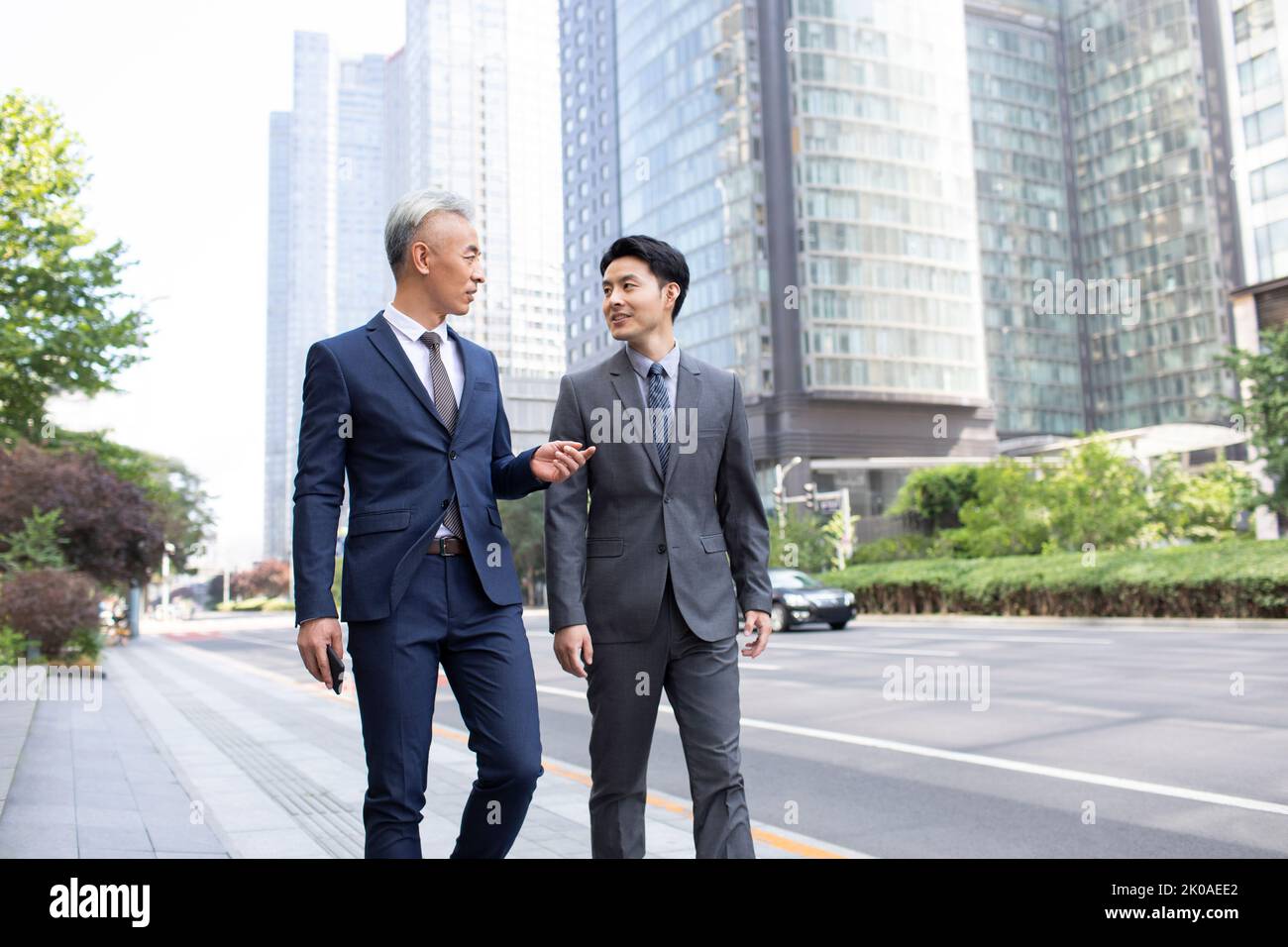 Confident Chinese businessmen talking outdoors Stock Photo - Alamy