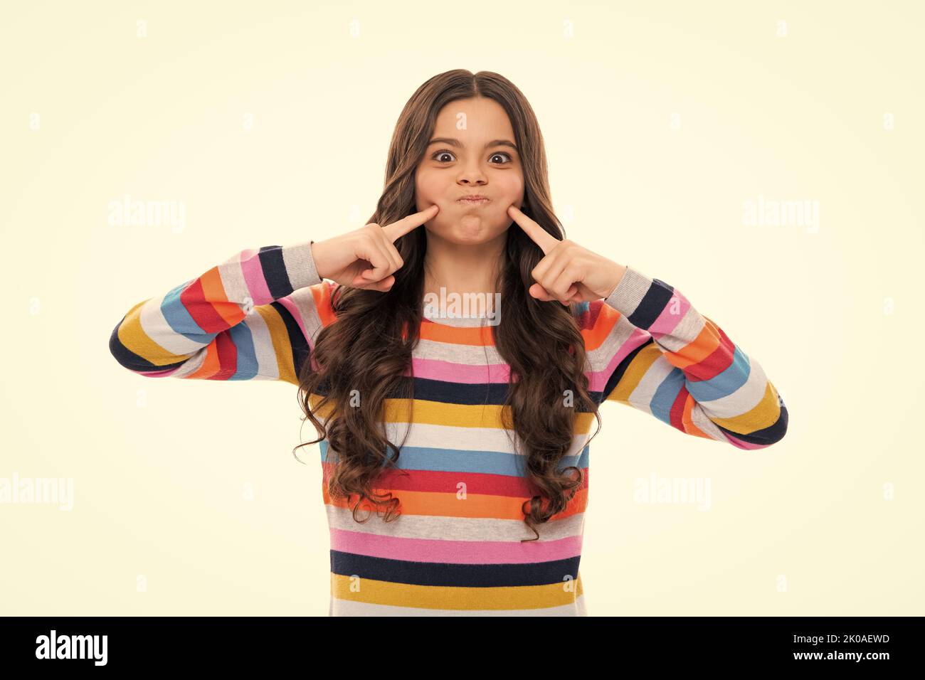 Funny face. Beautiful teen child pinching cheeks with index finger ...
