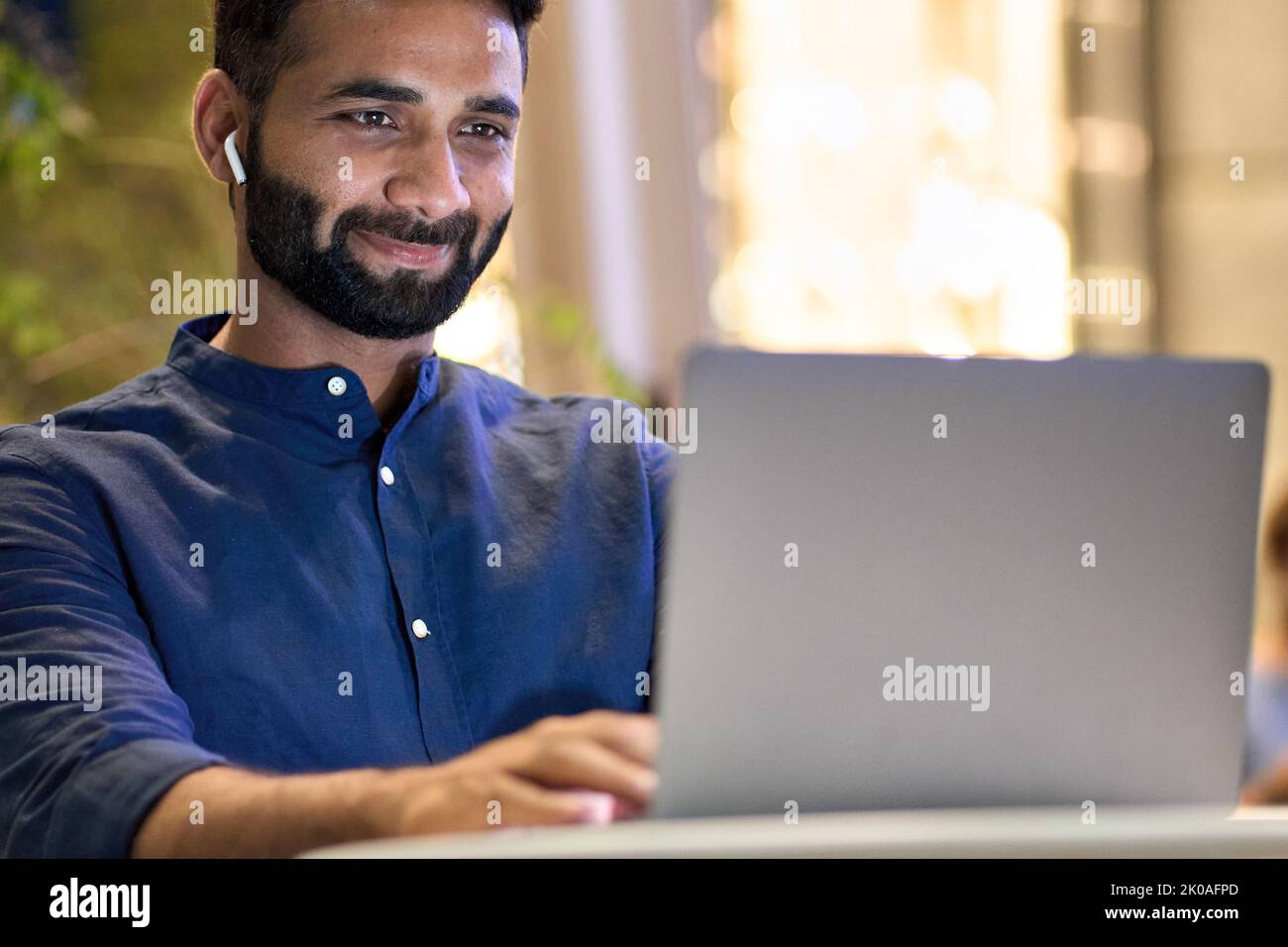 Indian business man using laptop computer remote working in night city ...