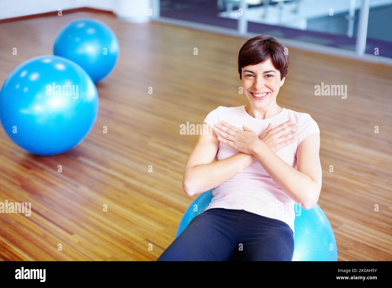Happy with the workout. Portrait of happy woman doing sit ups on ...