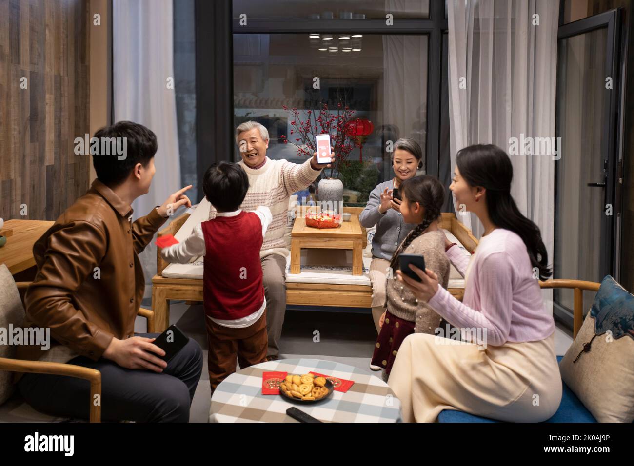 Happy family grabbing red envelope with smart phones Stock Photo - Alamy