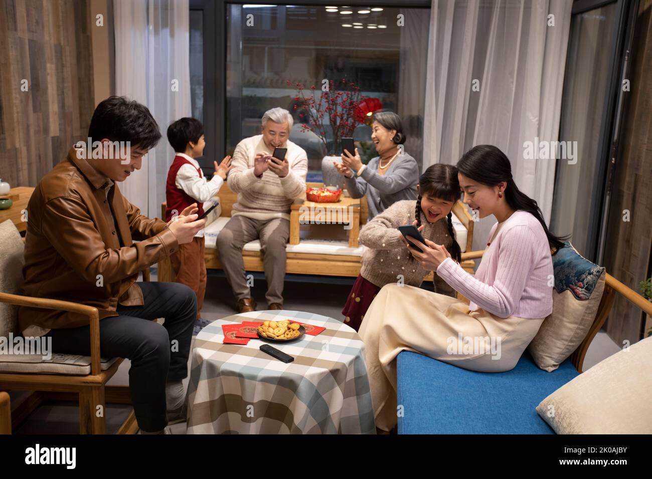Happy family grabbing red envelope with smart phones Stock Photo - Alamy